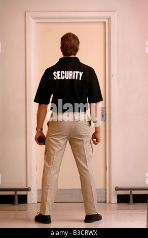 A SECURITY GUARD CHECKS AN IDENTIFICATION BADGE AT THE GATEHOUSE OF ...