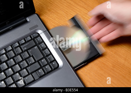 Inserting a CD into a CD rom drive on a laptop computer Stock Photo - Alamy