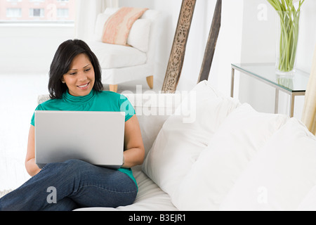 Plus size hispanic woman using laptop at home smiling happy pointing ...