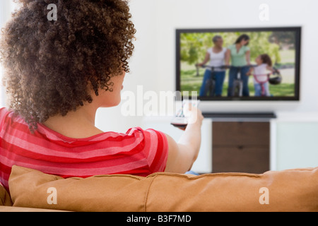 Woman watching television at home. Living room interior with TV on ...