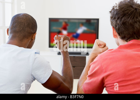 3 Men Cheering While Watching Flatscreen Television Stock Photo - Alamy