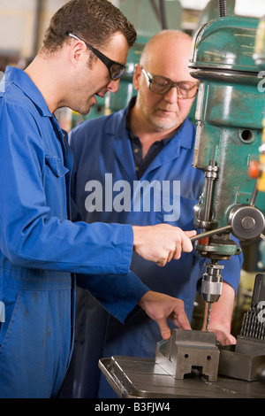 Two men operating factory machine Stock Photo - Alamy