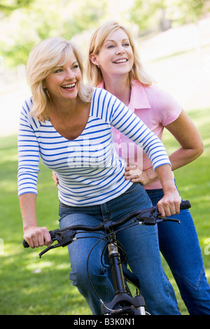 Girl riding bike in park. Portrait of a young female riding a bycicle ...