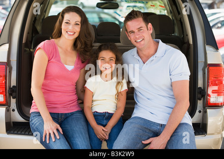 Family sitting in back of van smiling Stock Photo - Alamy