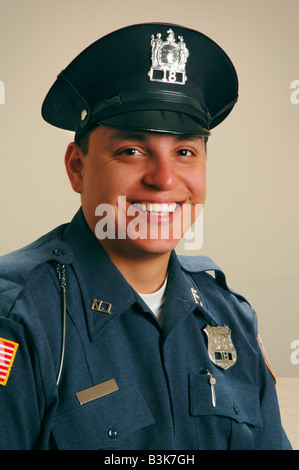 Portrait of a smiling police officer in uniform and holding a pair of ...