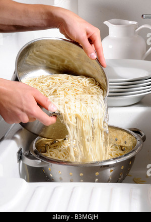 MAN DRAINING SPAGHETTI INTO COLLANDER Stock Photo - Alamy