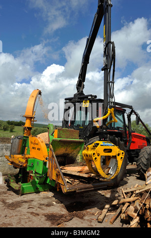 Tractor mounted chipper or shredder chips scrap wooden timber to be ...
