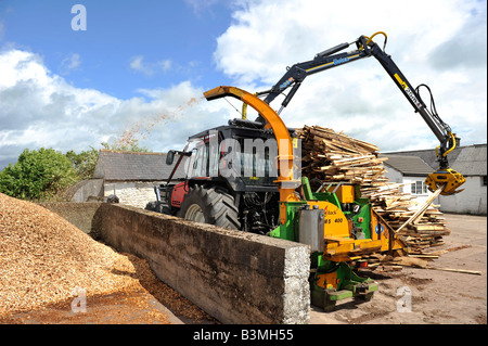Tractor mounted chipper or shredder chips scrap wooden timber to be ...