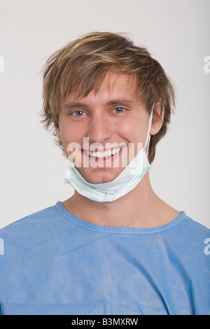Young blond man wearing doctor uniform holding stethoscope at clinic ...