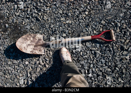 Shovel next to a foot laying on the ground in a construction area in ...