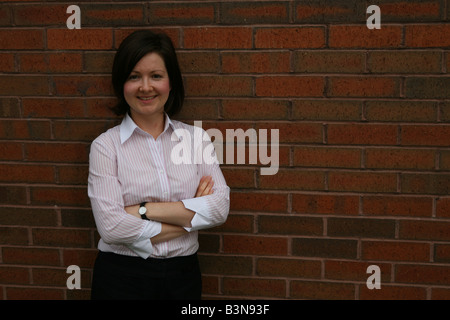 a portrait of a beautiful female solicitor leaning on a fence and ...