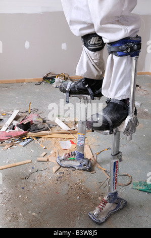 workman plasterer working on stilts Stock Photo - Alamy