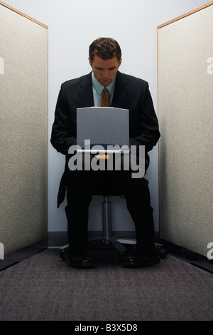Man on laptop in tiny cubicle Stock Photo - Alamy