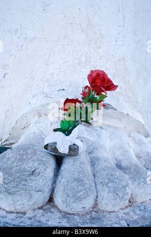 A red plastic rose between the toes of Nuestra Señora de Belen a statue ...