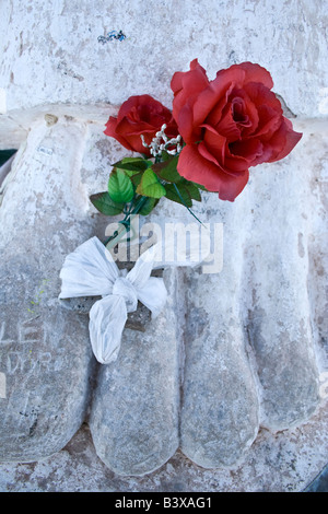 A red plastic rose between the toes of Nuestra Señora de Belen a statue ...