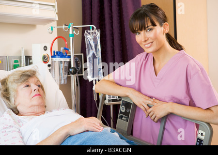 Nurse checking up on patient in bed Stock Photo - Alamy
