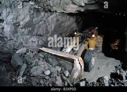 Miner in a fluorspar (fluorite) mine uses a flashlight to illuminate ...
