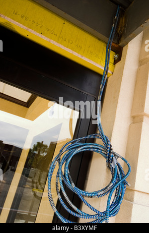 Coiled electrical cable hanging outside a building Stock Photo - Alamy