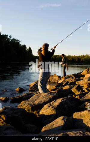 A couple fly fishing on the Moose River below the dam on Brassua Lake ...