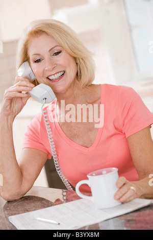 Woman enjoying a phone call and coffee outside, laughing and ...