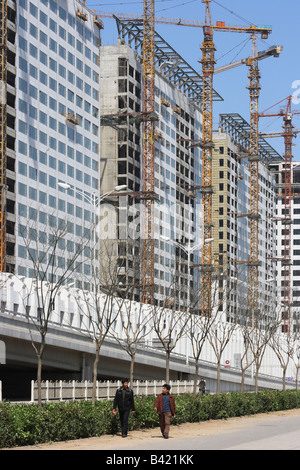 Chinese walk by a massive construction site in downtown Beijing on ...