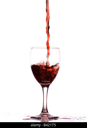 Action shot pouring red wine into a glass over a white background Stock ...