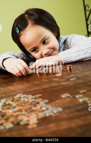 Girl (4-5) counting stack of coins, smiling, portrait Stock Photo - Alamy