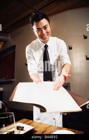 Waiter presenting menu Stock Photo - Alamy