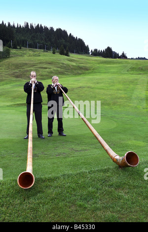 Two men playing the Alpenhorn or alphorn the strange Swiss musical ...