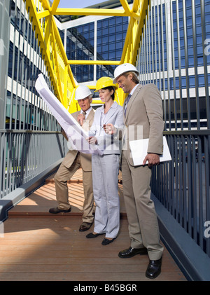 Group of construction workers looking at the plans and documents under ...