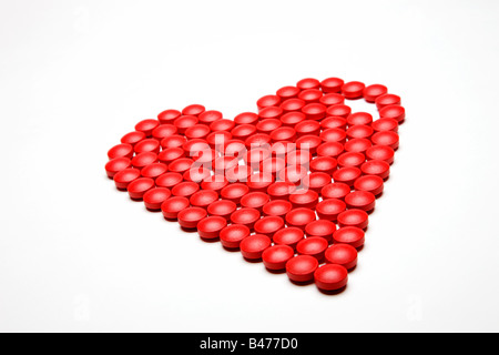heart-shaped tablets and red pill. on blue background. medicine ...
