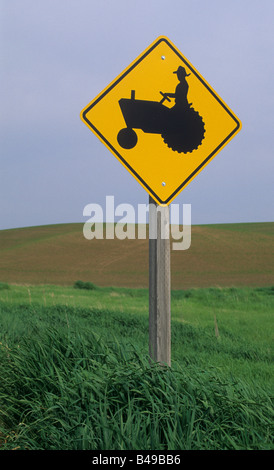 Farmer tractor crossing caution sign with orange sunrise Stock Photo ...