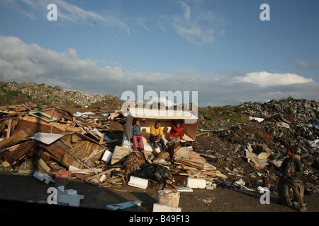 Roma gypsy children sitting in a box at Share, a slum next to a rubbish ...