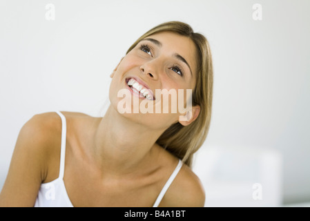 Portrait of laughing head tilted back teenage girl sitting outdoors ...