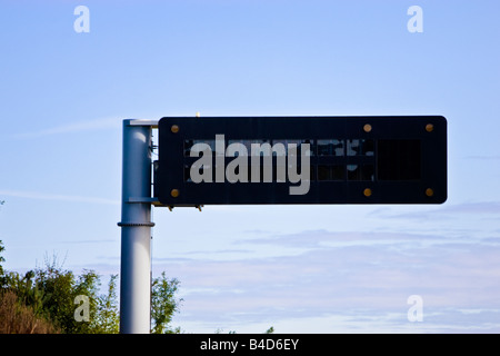 Overhead electronic English motorway warning signs of speed and queue ...