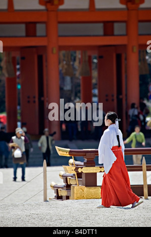 Miko shrine maiden in traditional shinto costume at Shimon main gate ...