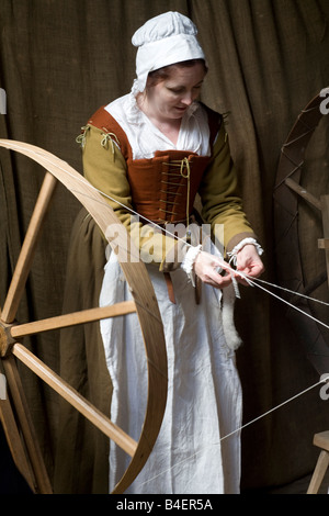Lady spinning wool thread with spinning wheel Stock Photo - Alamy