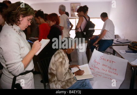 A group of women sitting on a Palestinian flag carry shroud dolls ...