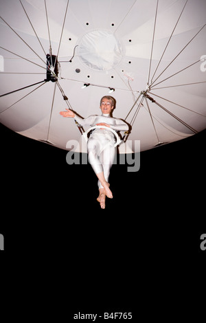 An acrobat is suspended below the Heliosphere, a giant helium balloon ...