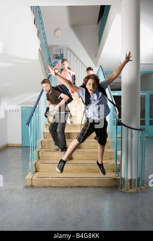 Four pre-adolescent children running down stairs excited Stock Photo ...