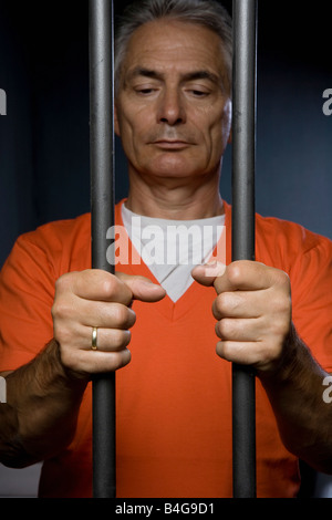A prisoner standing behind prison bars Stock Photo - Alamy