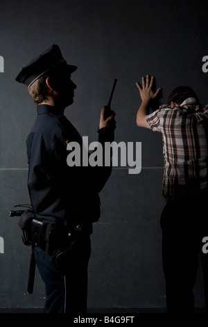 Police Officer Arresting Two Men in a Grassy Field Stock Photo - Alamy