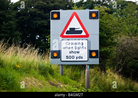 Warning road sign. Tanks crossing and sudden gunfire Stock Photo - Alamy