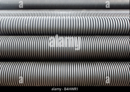 Rows of black ribbed tubes are building materials on a construction ...
