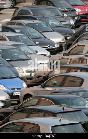 A busy street with many cars parked on the side of the road. The street ...