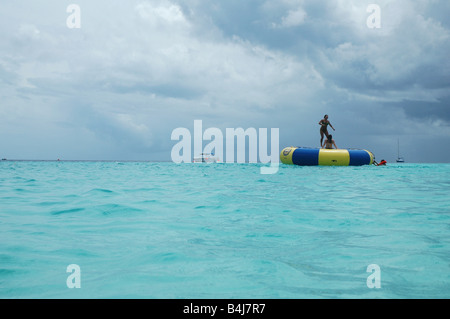 Teenagers floating on an innertube Stock Photo - Alamy