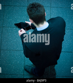 Young businessman checking his wallet Stock Photo - Alamy
