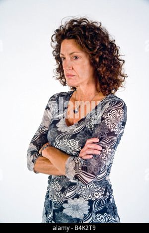 Woman standing with arms crossed on blue background Stock Photo - Alamy