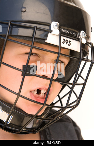 A young boy shows off his missing teeth while in his hockey gear Stock ...