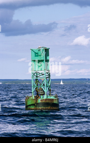 Green bell buoy in ocean channel marker with clouds and blue sky Stock ...